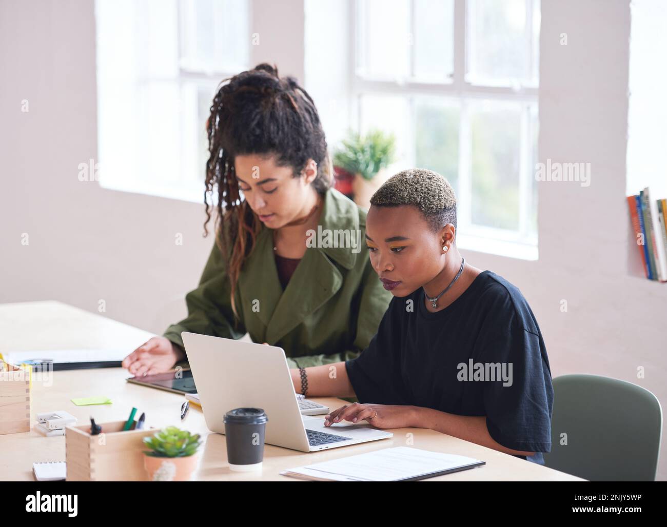 College students working together two young women friends brainstorming ...