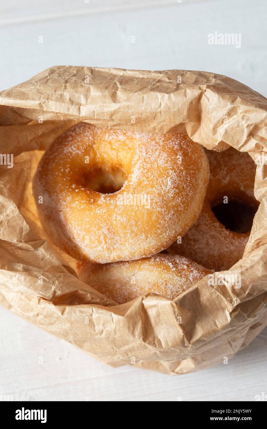 Ring doughnuts, or donuts, in a brown paper bag. Sustainable plastic ...