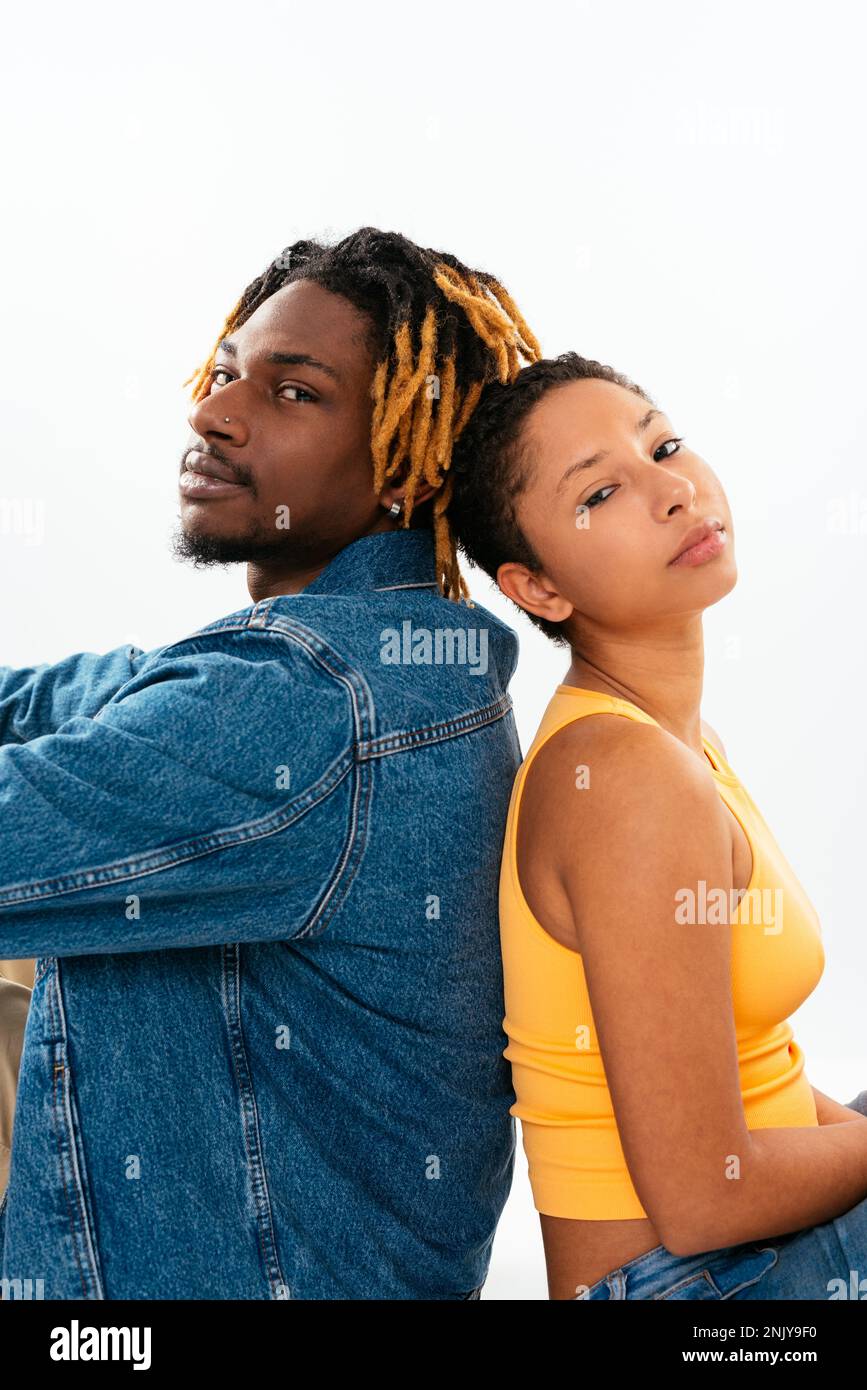 From above of ethnic boyfriend and girlfriend in denim clothes sitting ...