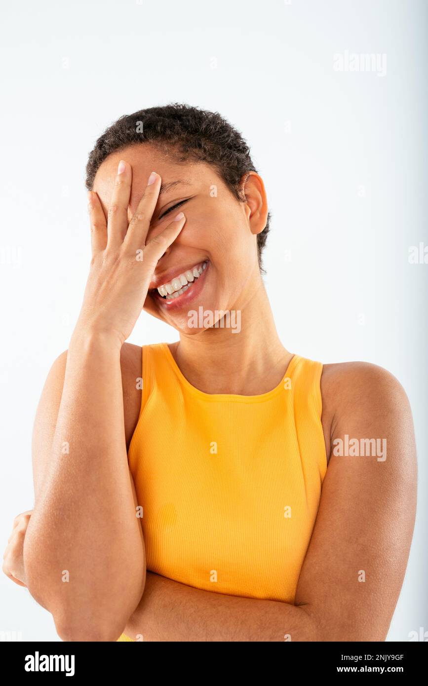 Happy young African American female with short hair in yellow top doing ...