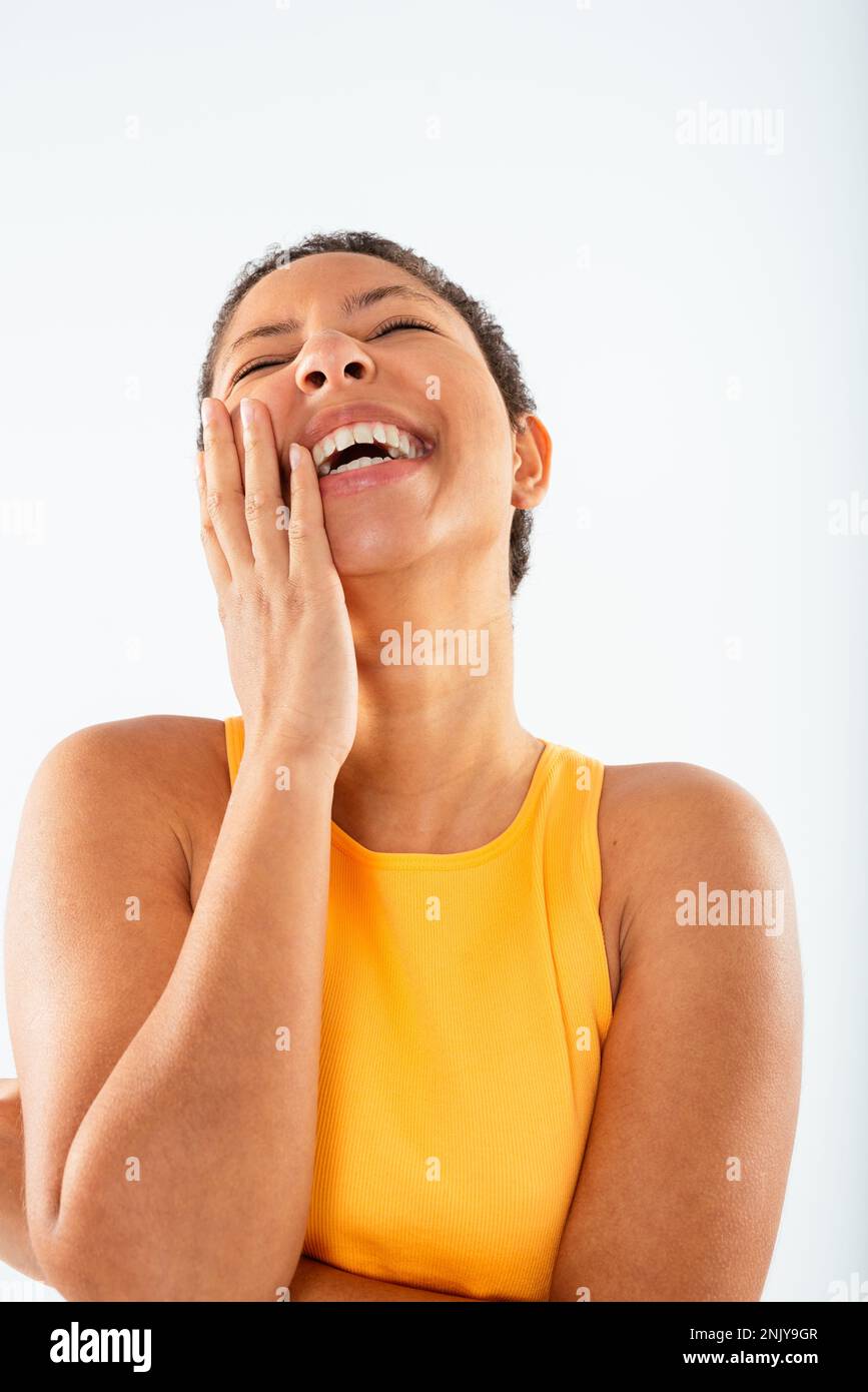 Happy young African American female with short hair in yellow top doing ...