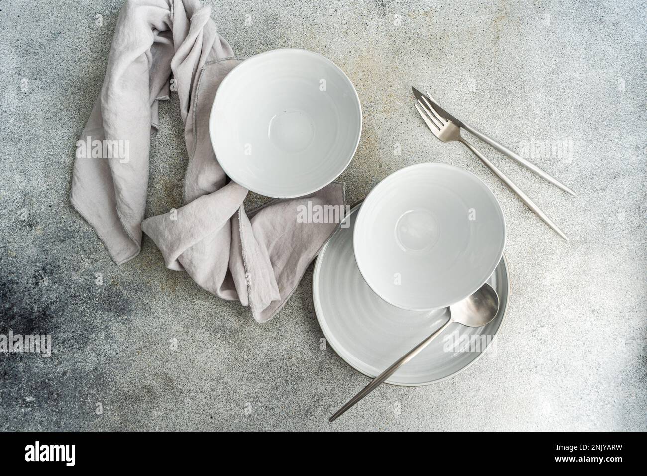 Minimalistic white and grey table setting on concrete table Stock Photo ...