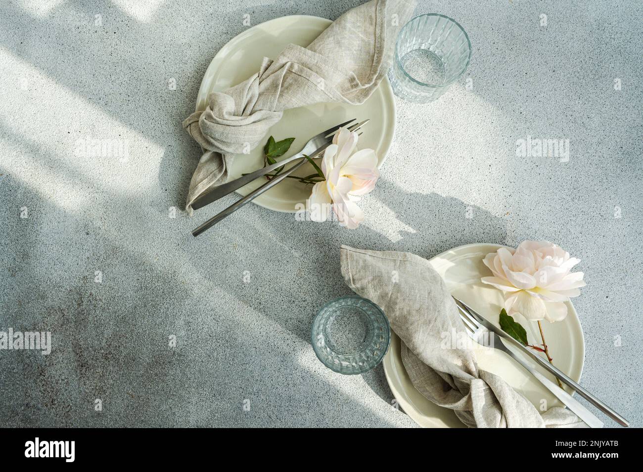 Table setting with white ceramic plates and white blooming roses Stock ...