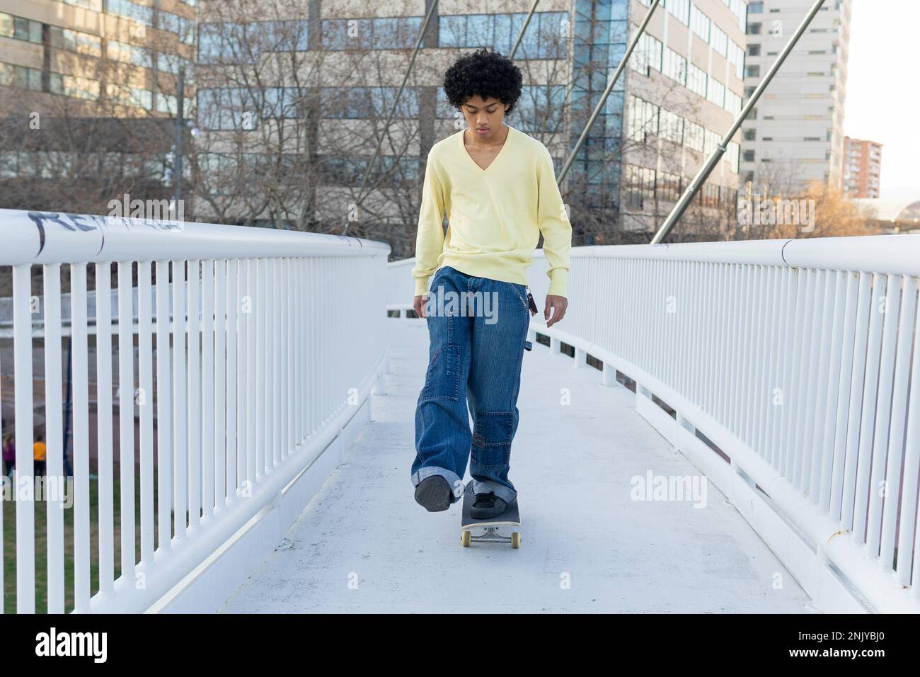 Full body of concentrated young Asian male skater in casual wear with ...