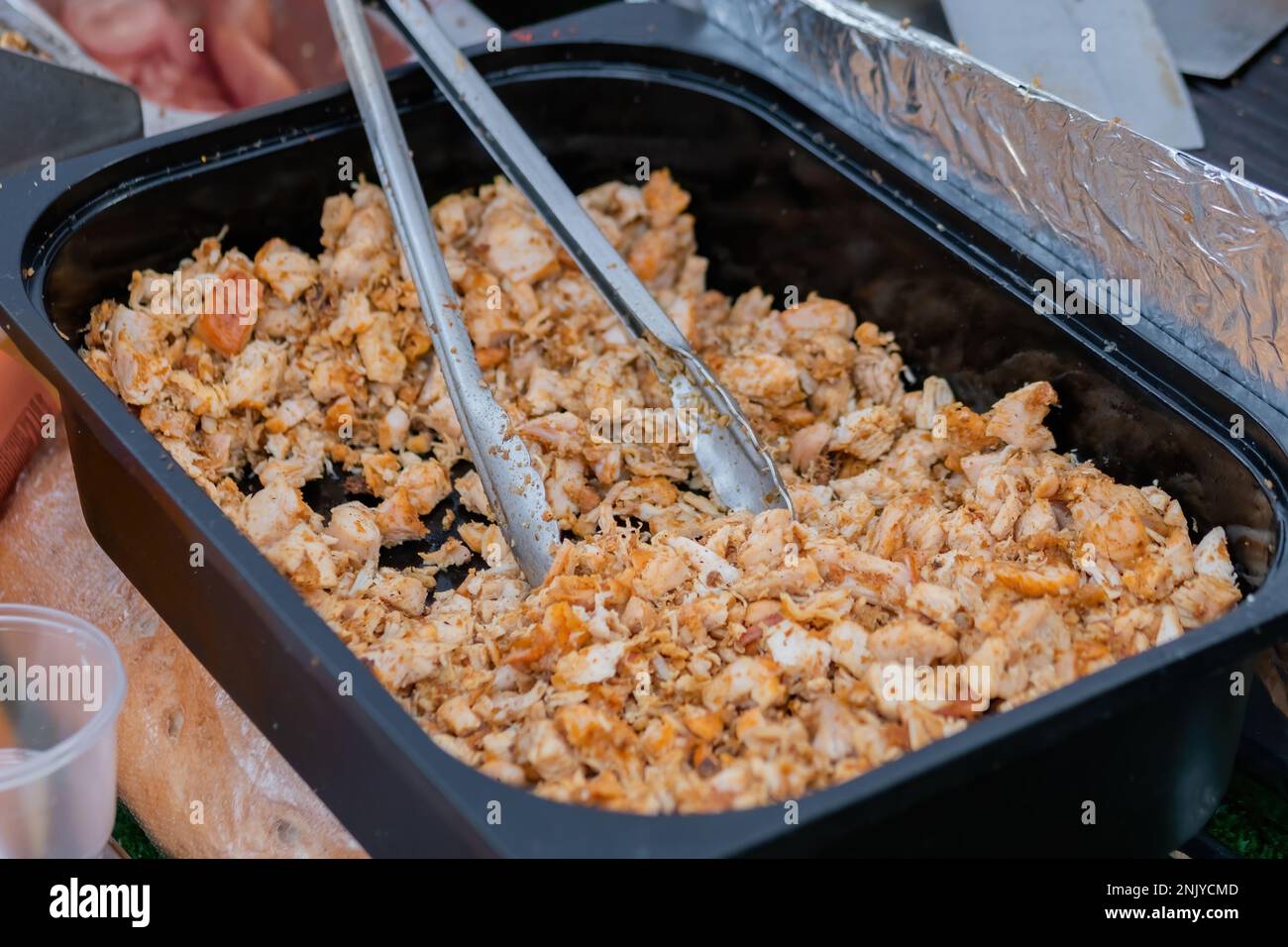 Cooked roasted chicken meat pieces in food container at local food ...