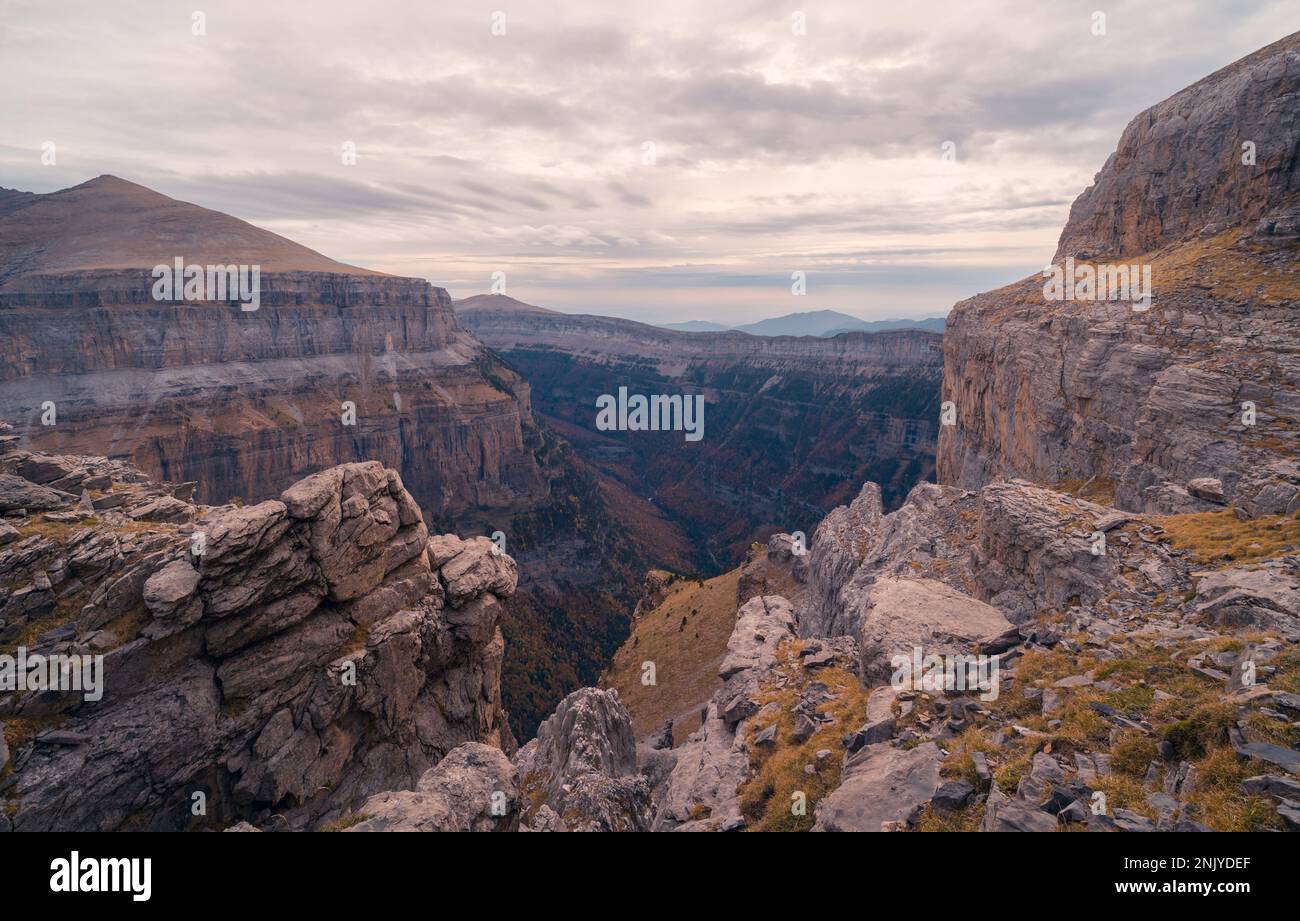 Picturesque view of rocky mountains with uneven slopes under cloudy sky ...