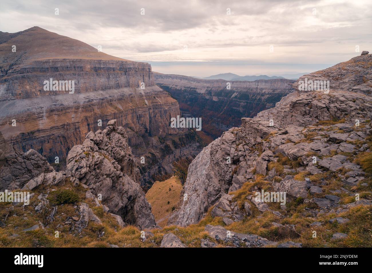 Picturesque view of rocky mountains with uneven slopes under cloudy sky ...