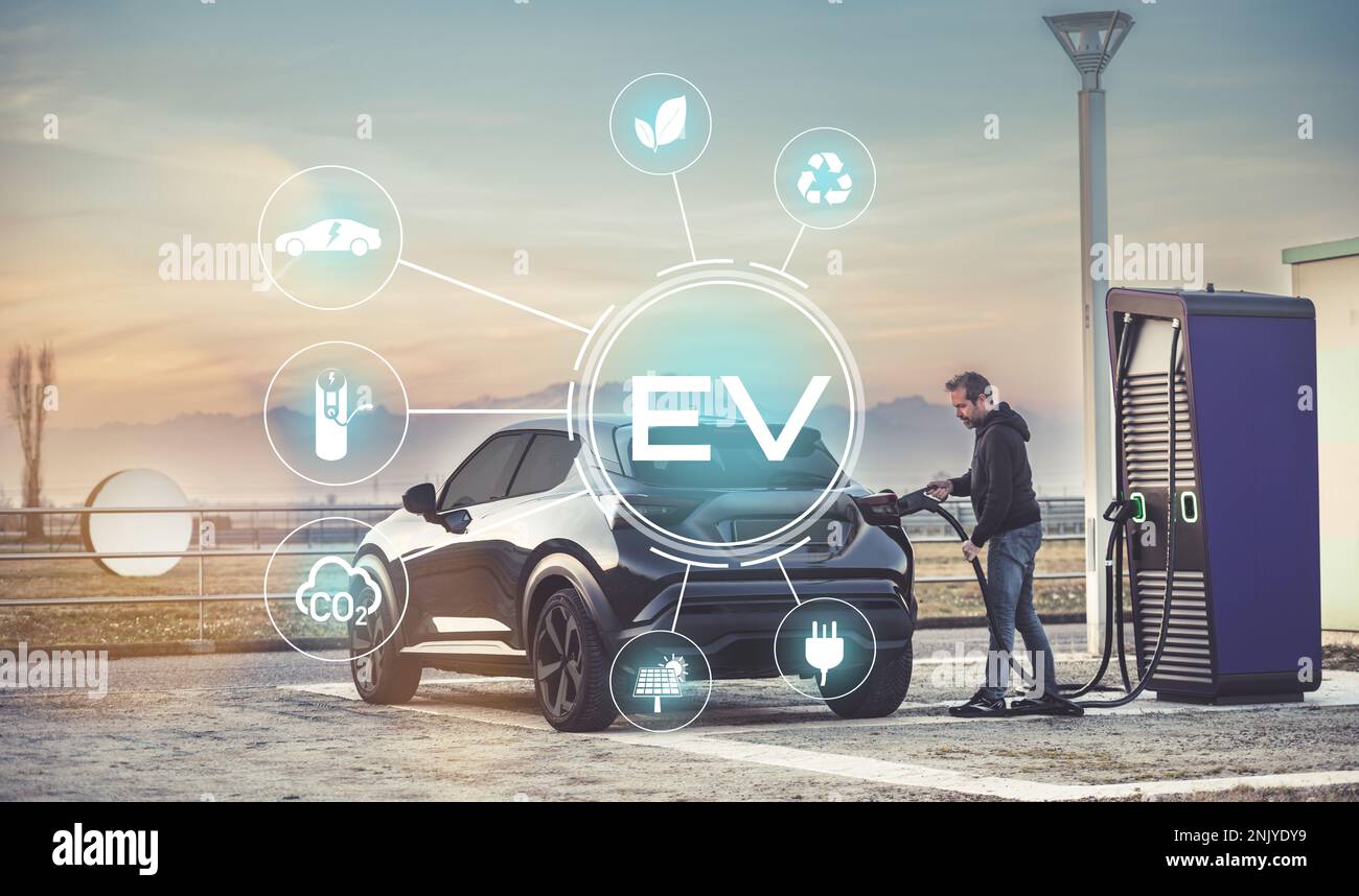 Man charging hybrid EV. Charge battery of electric vehicle. Green eco ...