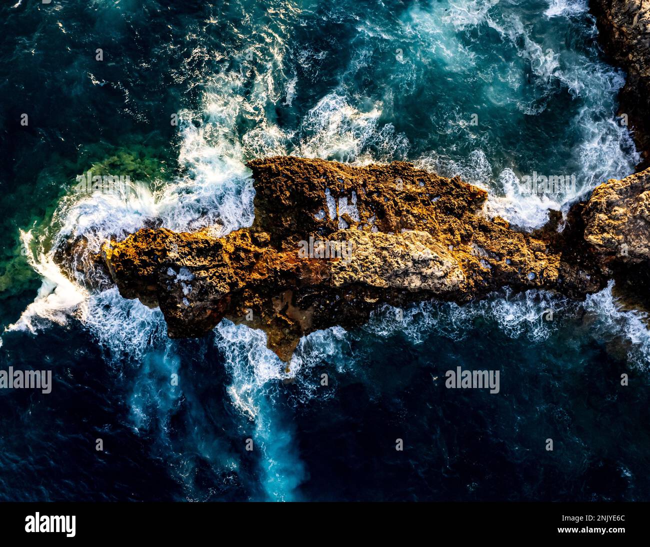 Top aerial view of powerful stormy sea waves splashing on rocky cliff ...
