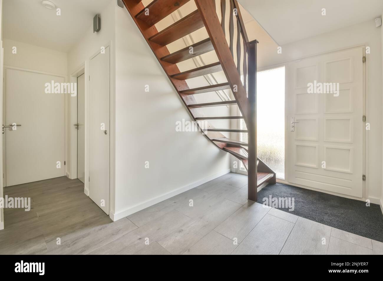 Interior of light corridor of modern house with wooden steps on sunny ...