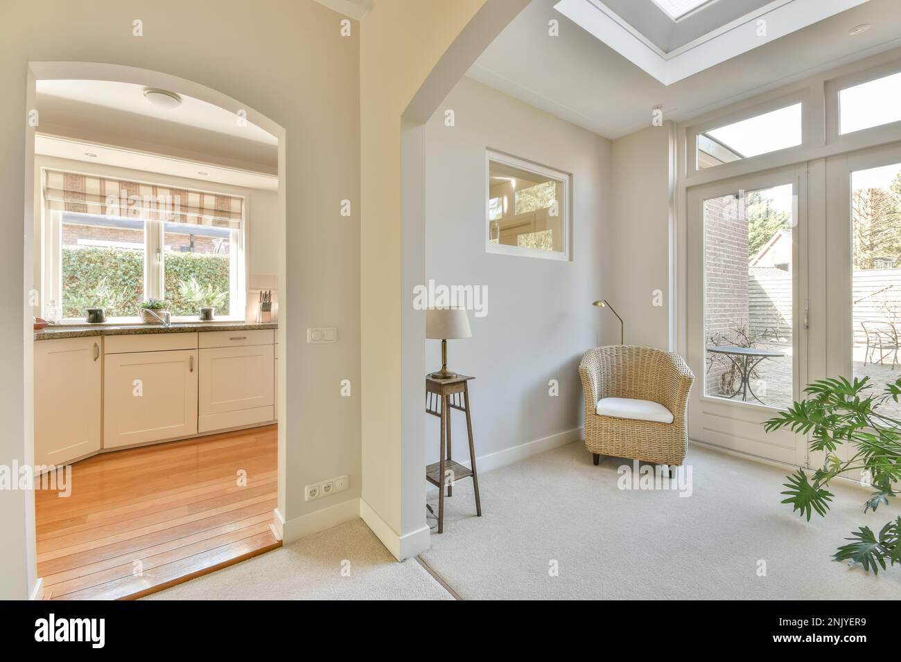 Contemporary apartment with arched passages leading to kitchen and room ...