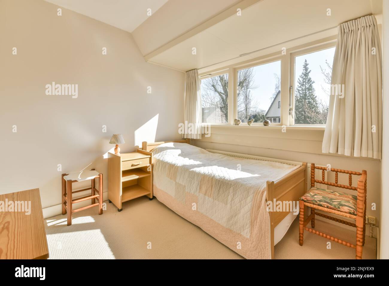 Interior of bedroom with wooden furniture and bed under window with ...