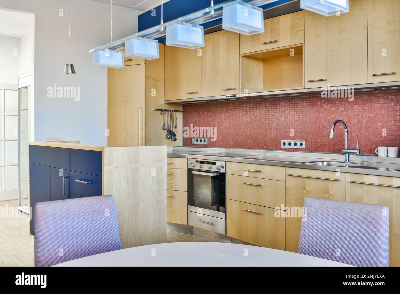 Interior design of modern kitchen with suspended lamps over wooden ...