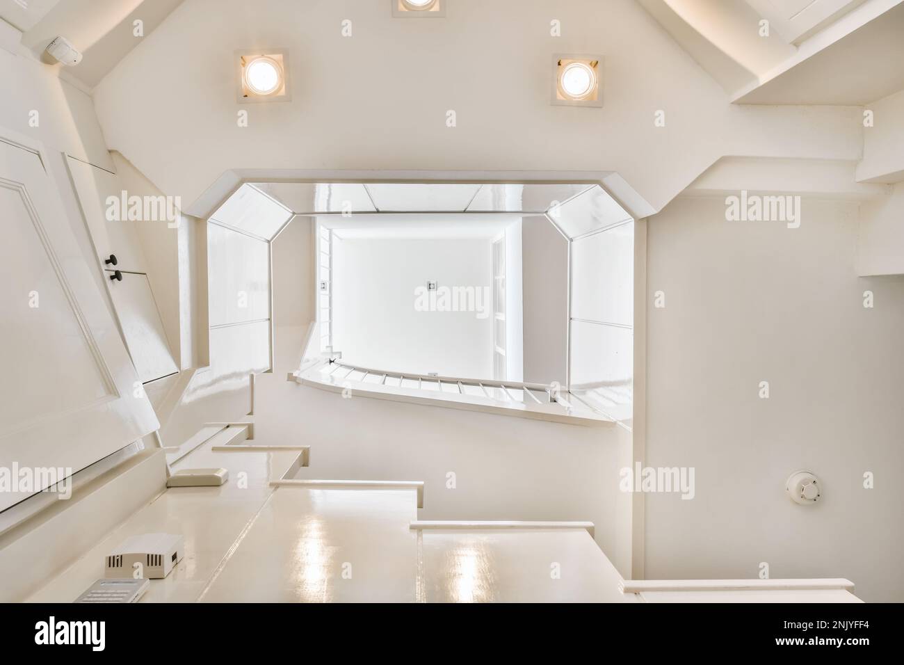 Directly below interior of while spiral staircase and railing in modern ...