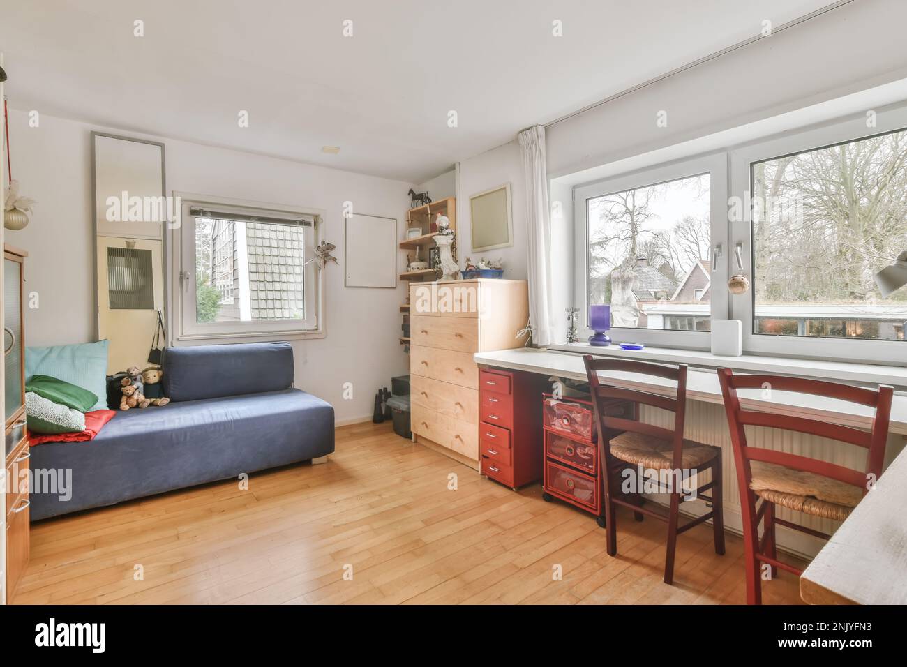 Interior of spacious living room with wooden floor and blue couch ...