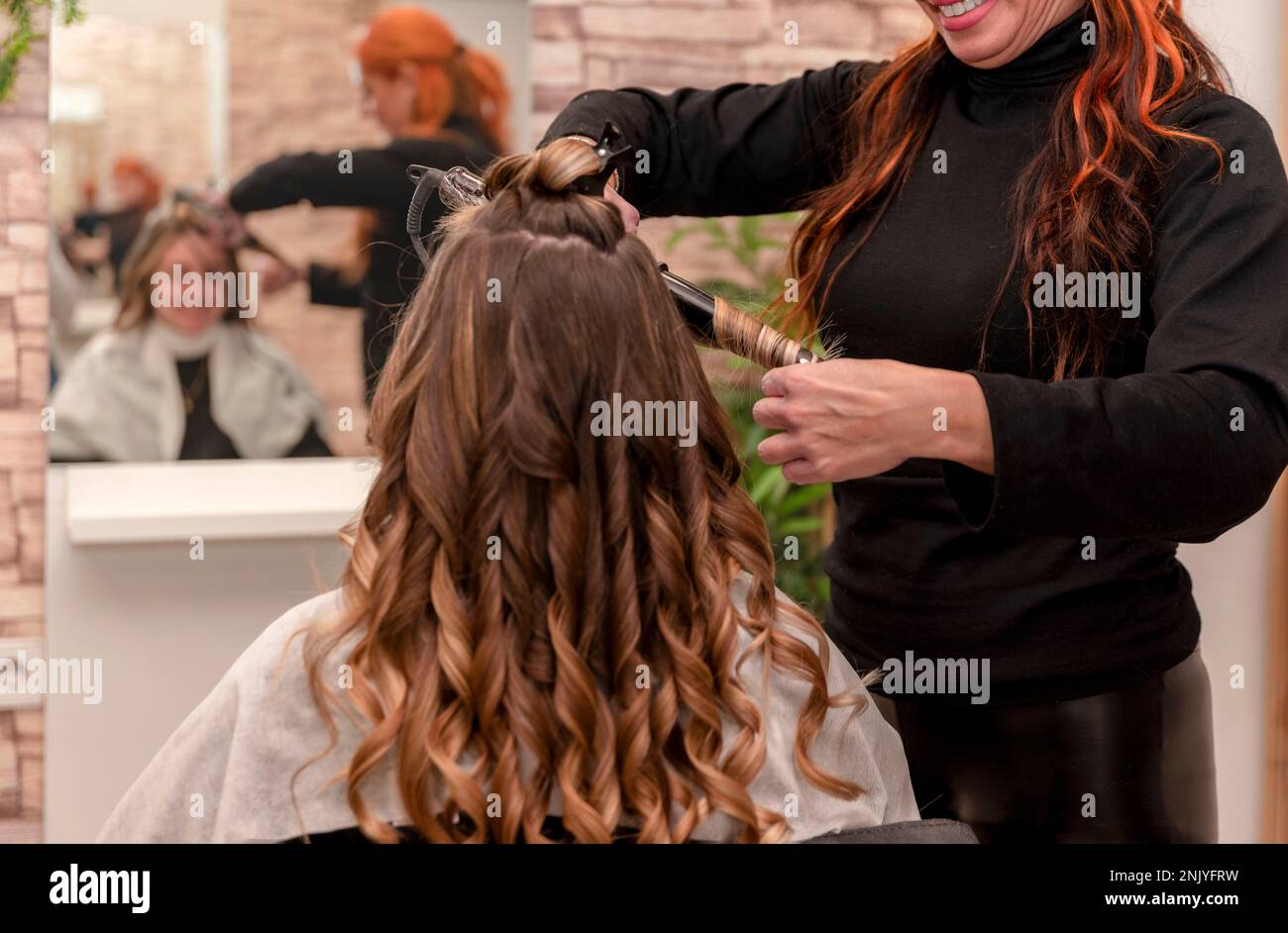 Hairdresser in black uniform curling hi-res stock photography and ...