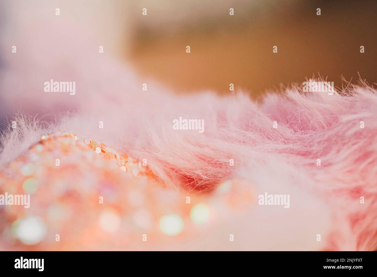 Soft pink fluffy fur with shiny sparkles on surface against blurred ...