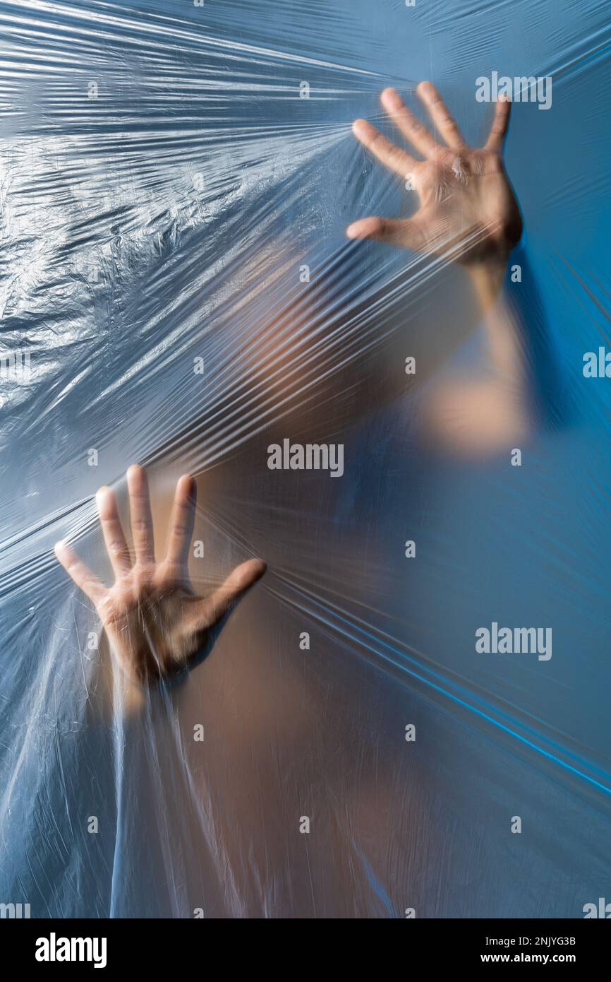 Female touching transparent cellophane while standing behind it concept ...