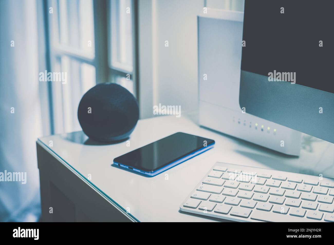 Smartphone, wifi speaker, router and computer on desk. Technology ...