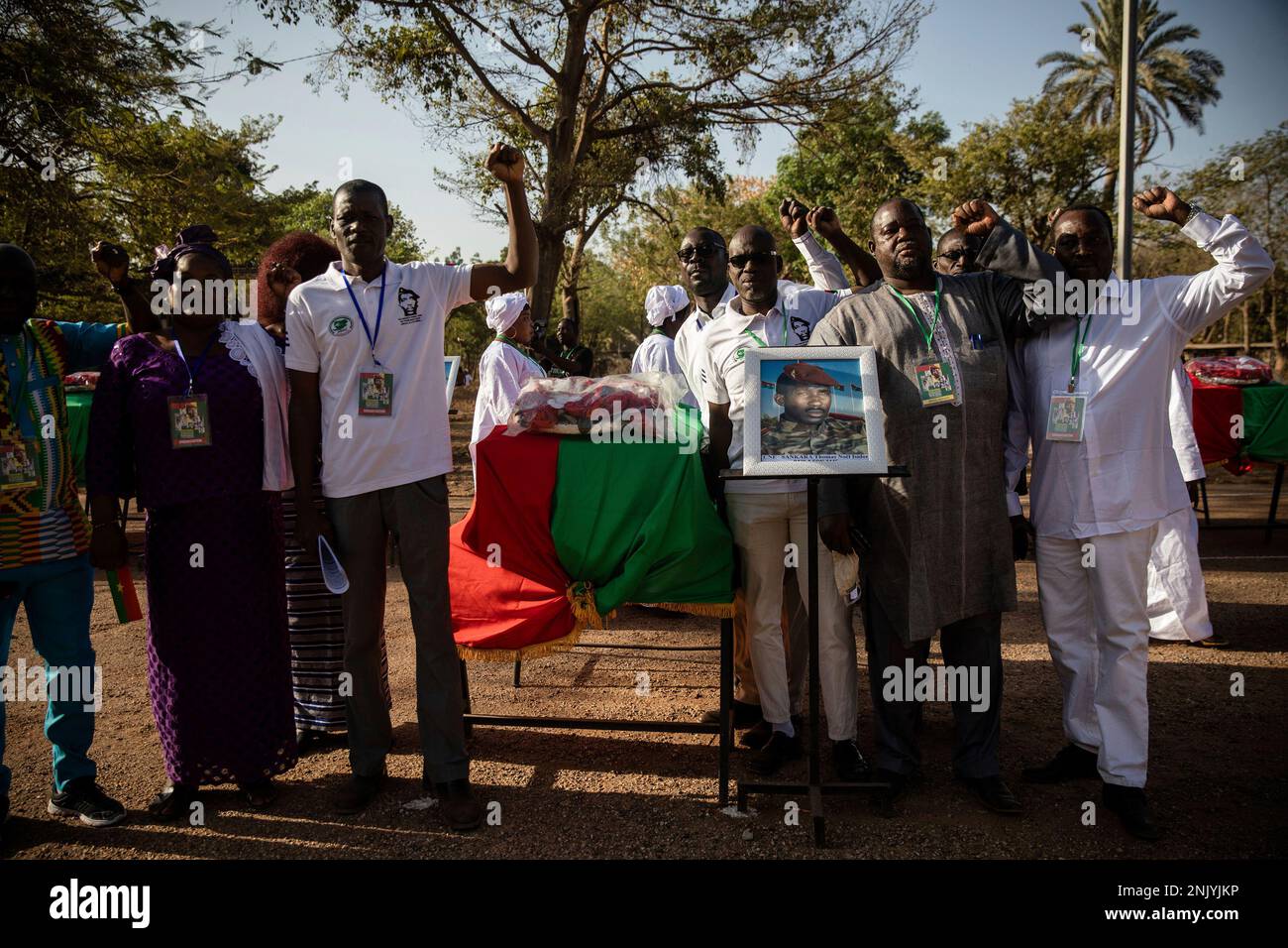 People pose for a picture as they stand next to the coffin containing ...