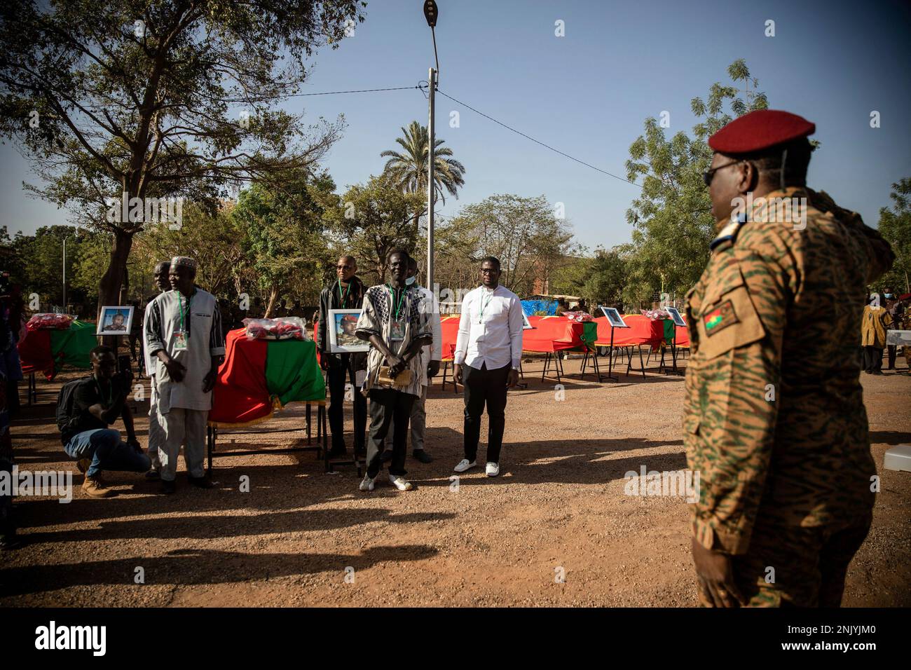People pose for a picture as they stand next to the coffin containing ...
