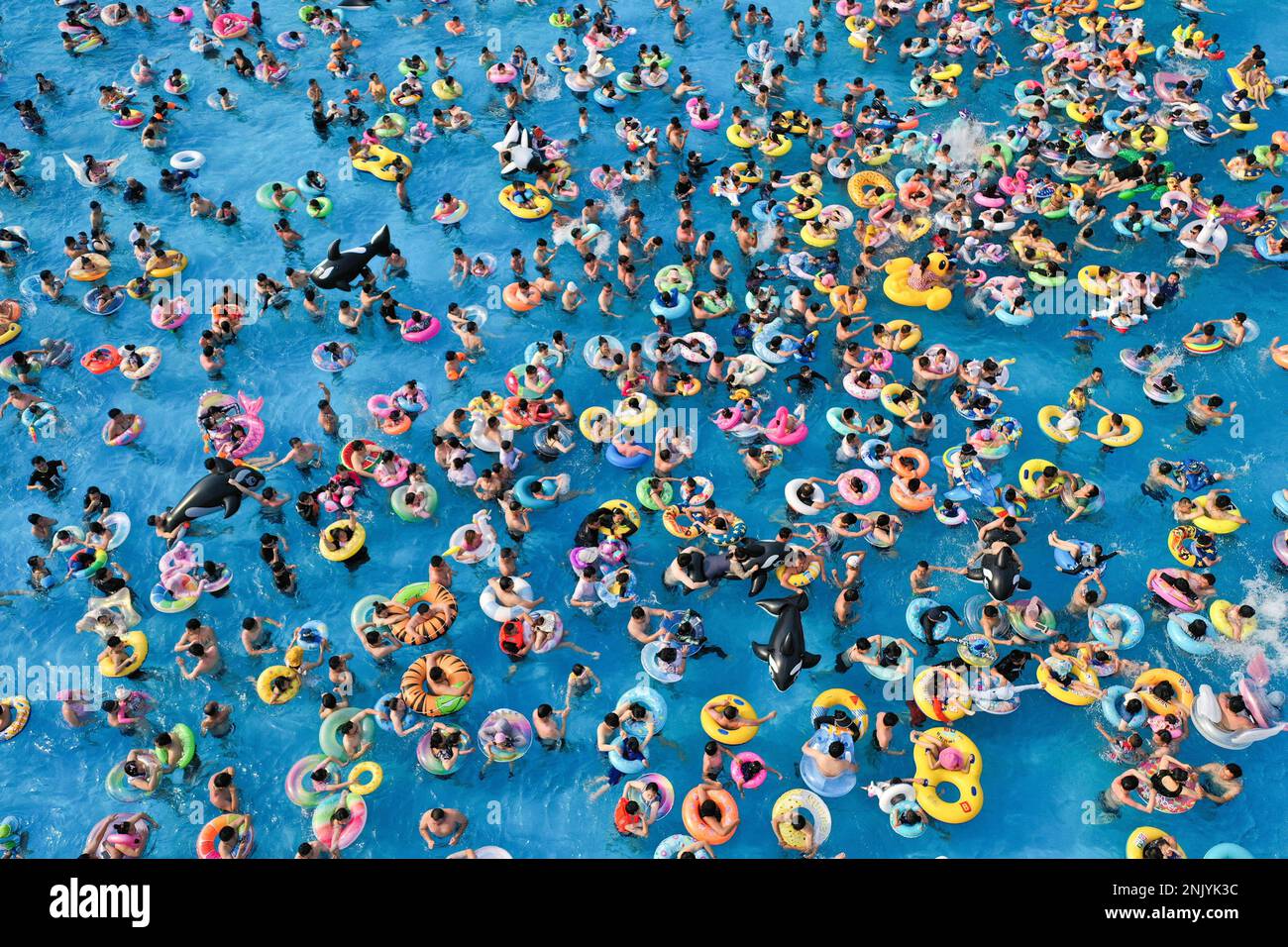 People wait for an artificial tide in a giant pool in a water park in ...