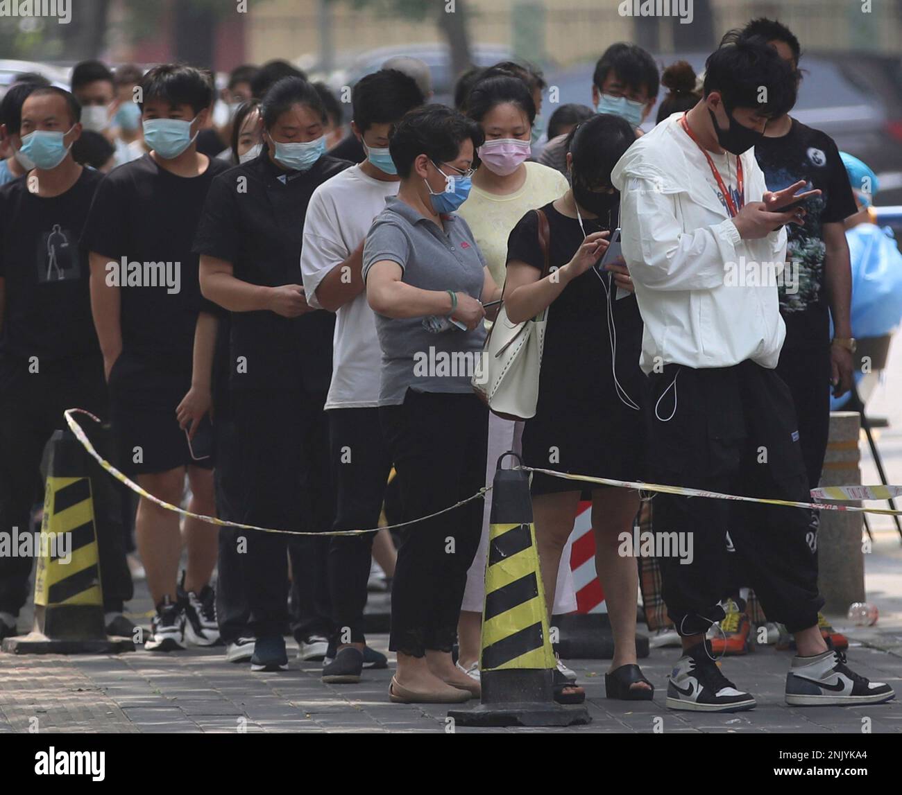 People wait in line to take a PCR test at Chaoyang District in Beijing ...