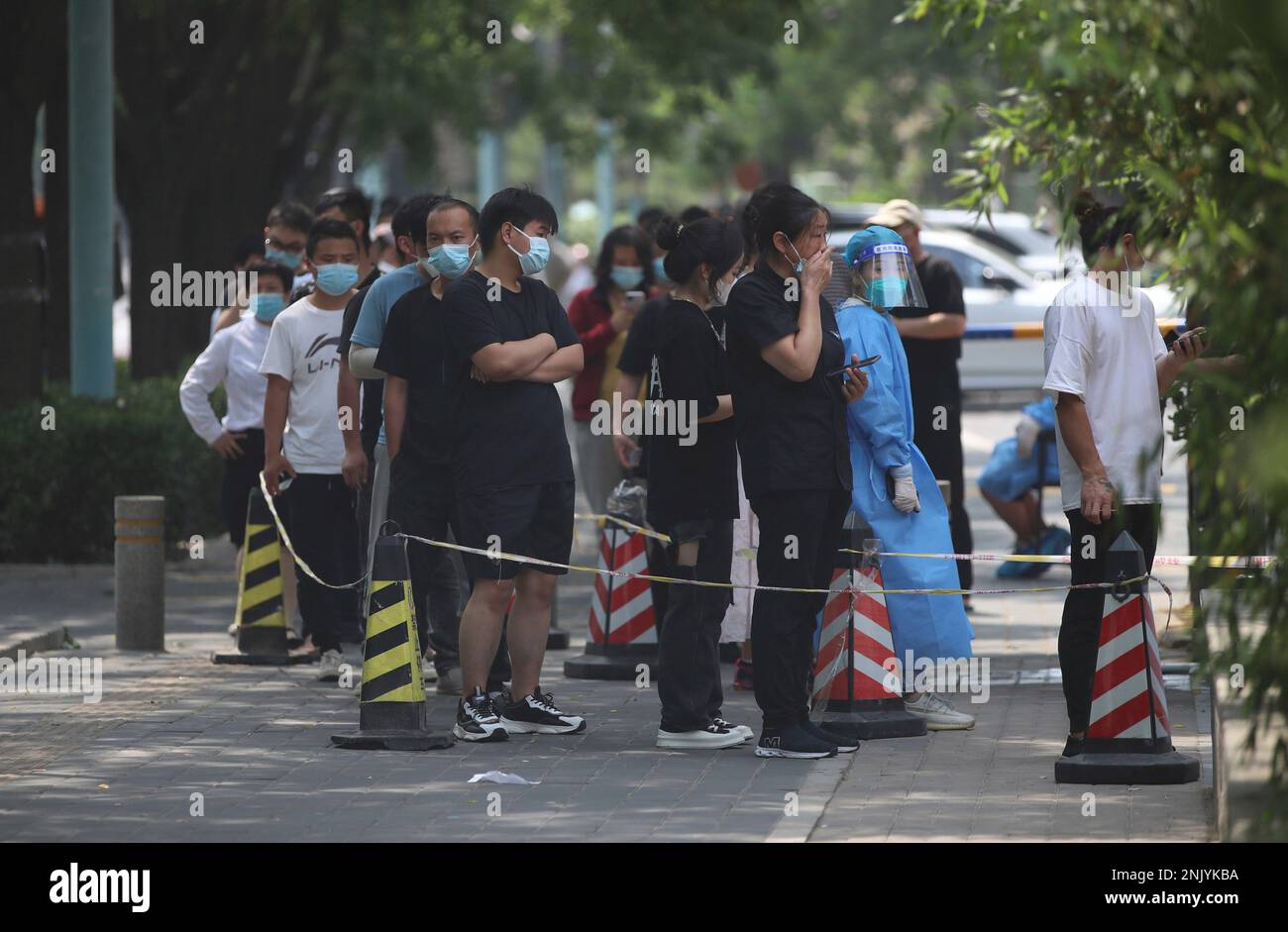 People wait in line to take a PCR test at Chaoyang District in Beijing ...