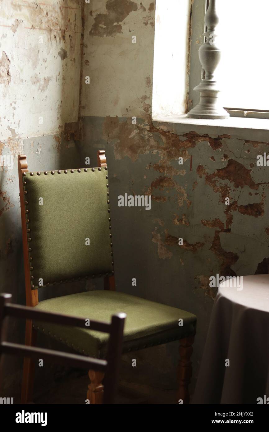 green chair and table put under antique window for set up the temporary ...