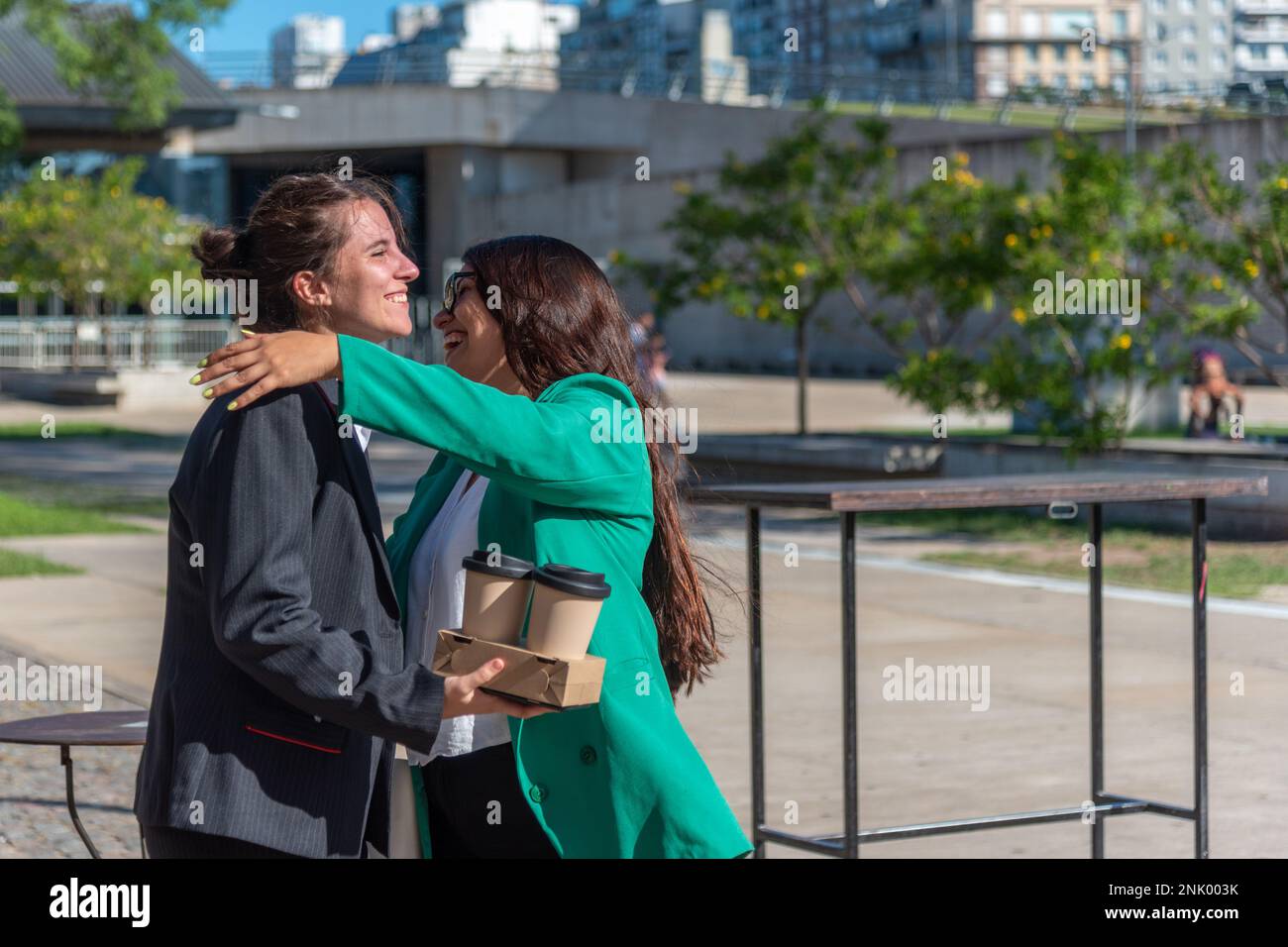 Two business colleagues hugging while meeting outdoors Stock Photo - Alamy