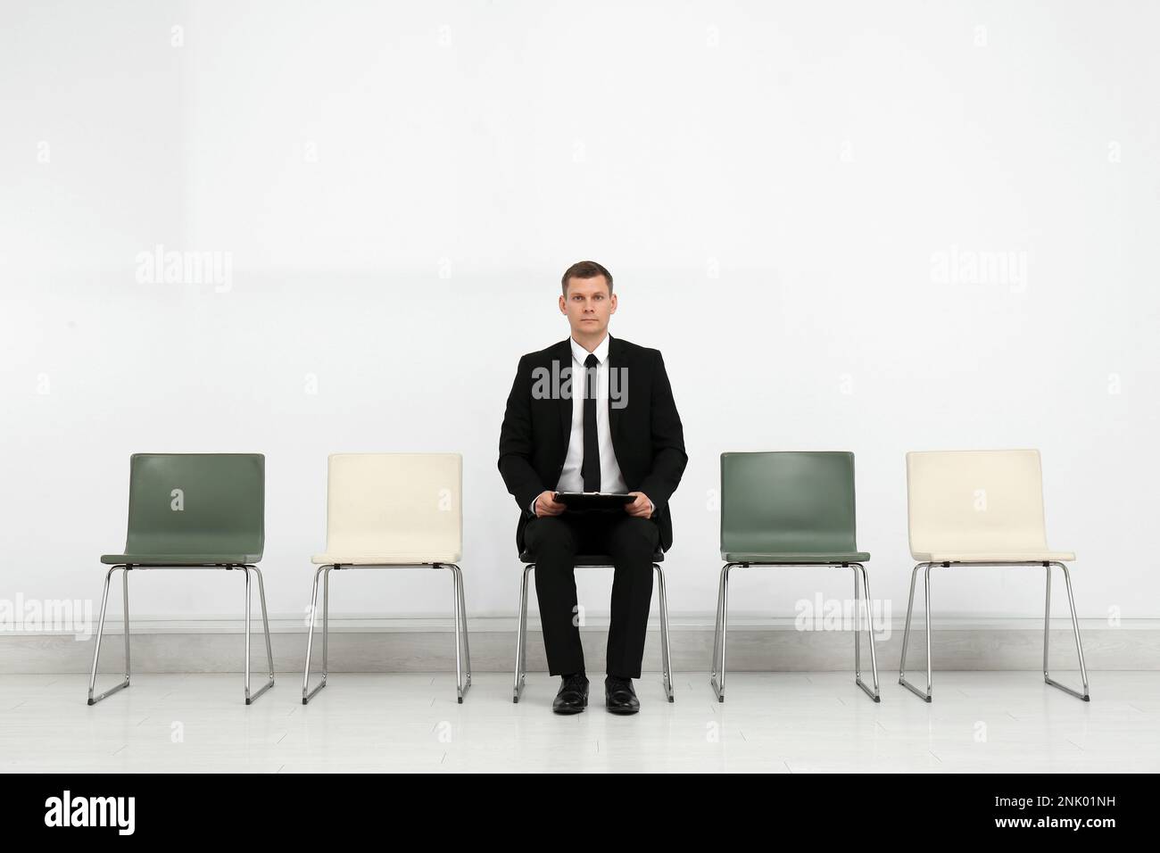 Man with clipboard waiting for job interview in office hall Stock Photo ...