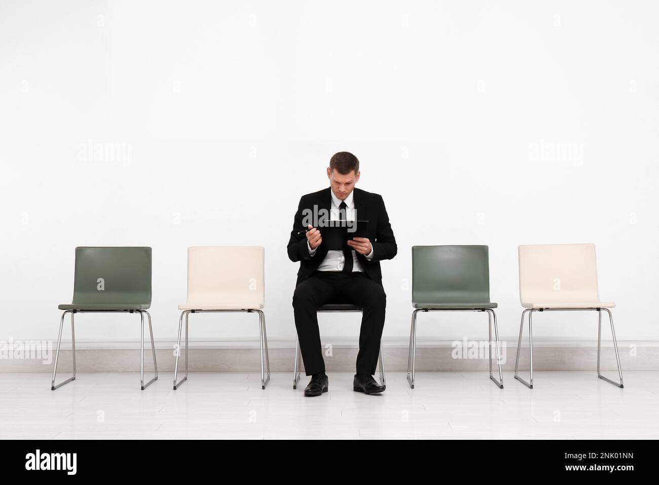 Man with clipboard waiting for job interview in office hall Stock Photo ...