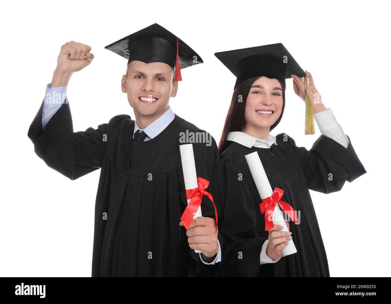 Happy students in academic dresses with diplomas on white background ...