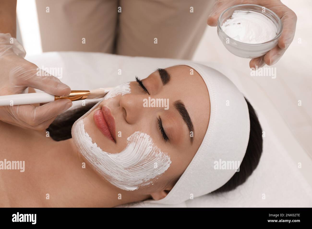 Young woman during face peeling procedure in salon Stock Photo - Alamy