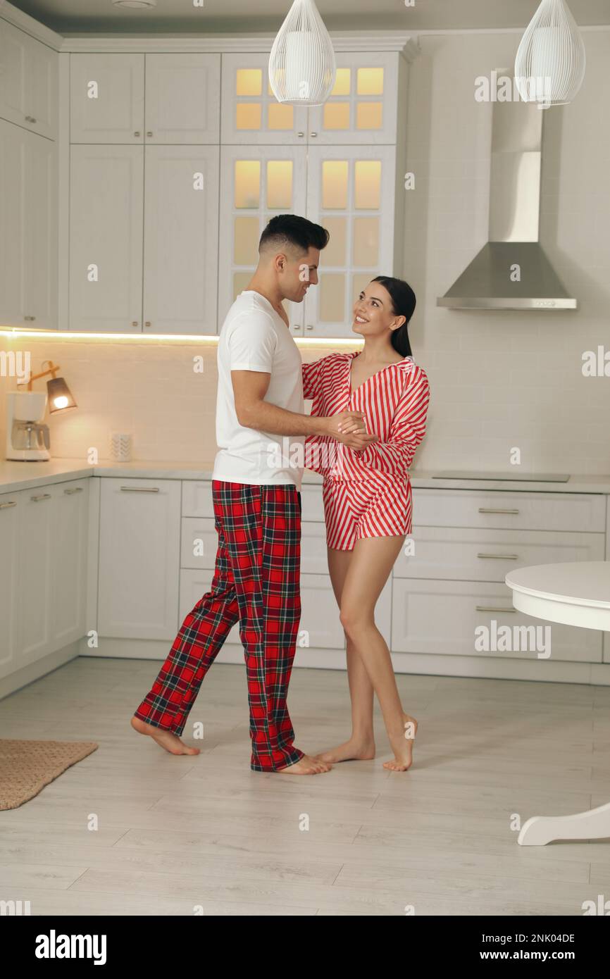 Happy couple wearing pyjamas and dancing in kitchen Stock Photo - Alamy