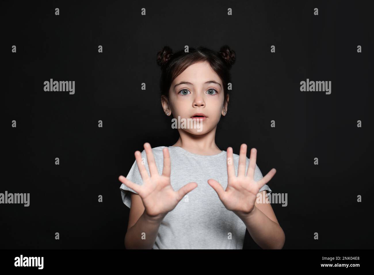 Little girl feeling fear on black background Stock Photo - Alamy