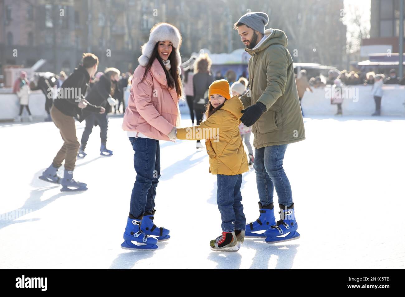 Happy family spending time together at outdoor ice skating rink Stock ...
