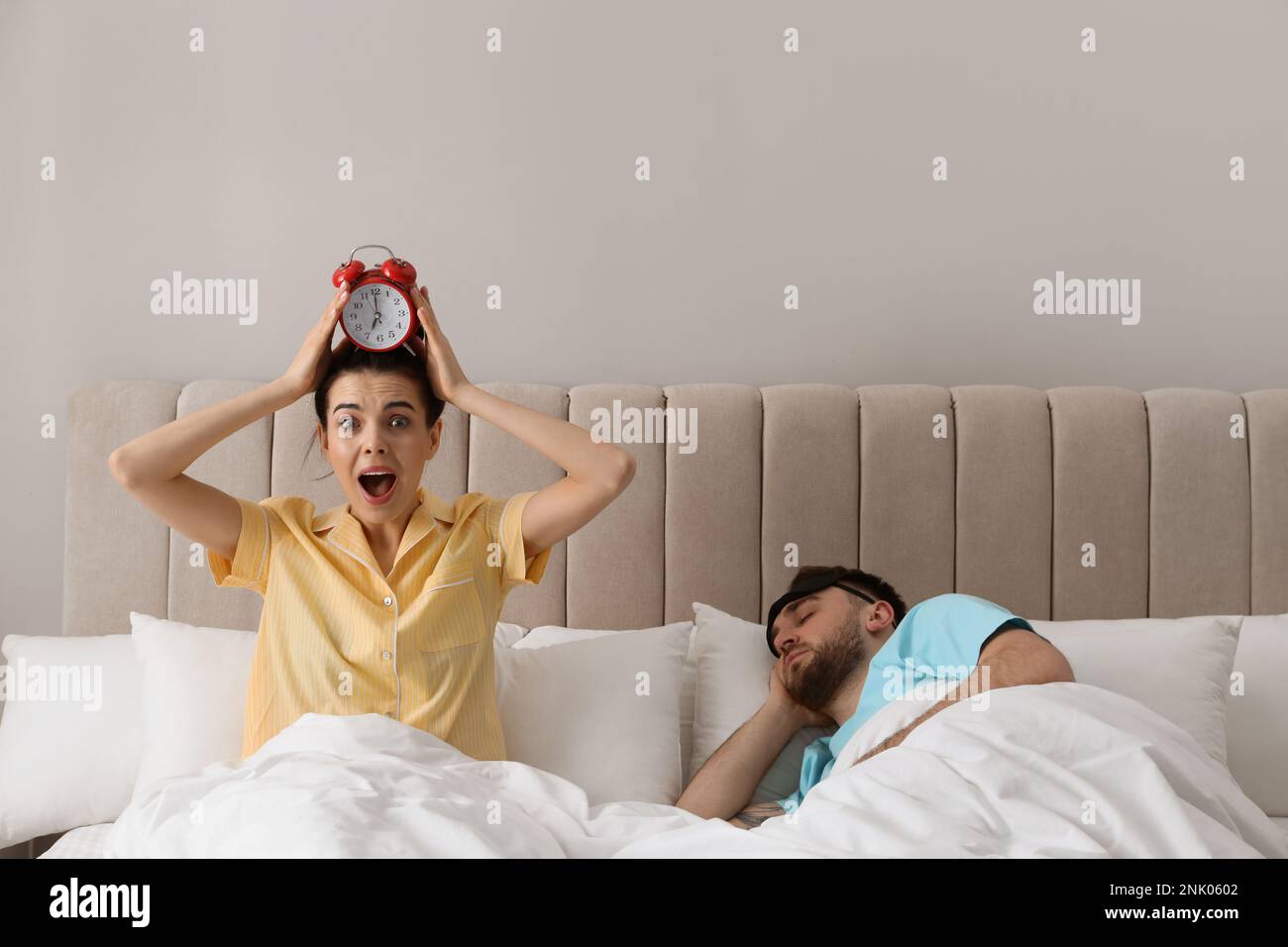 Emotional woman and sleeping man in bedroom. Being late concept Stock ...