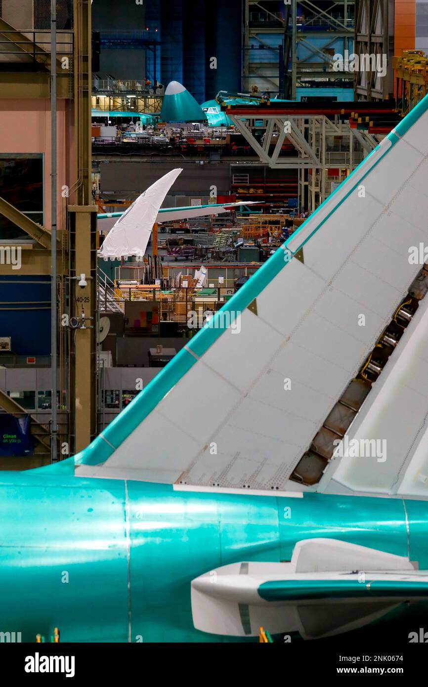 A Boeing 747 with its nose cone up is seen behind the winglet of the ...