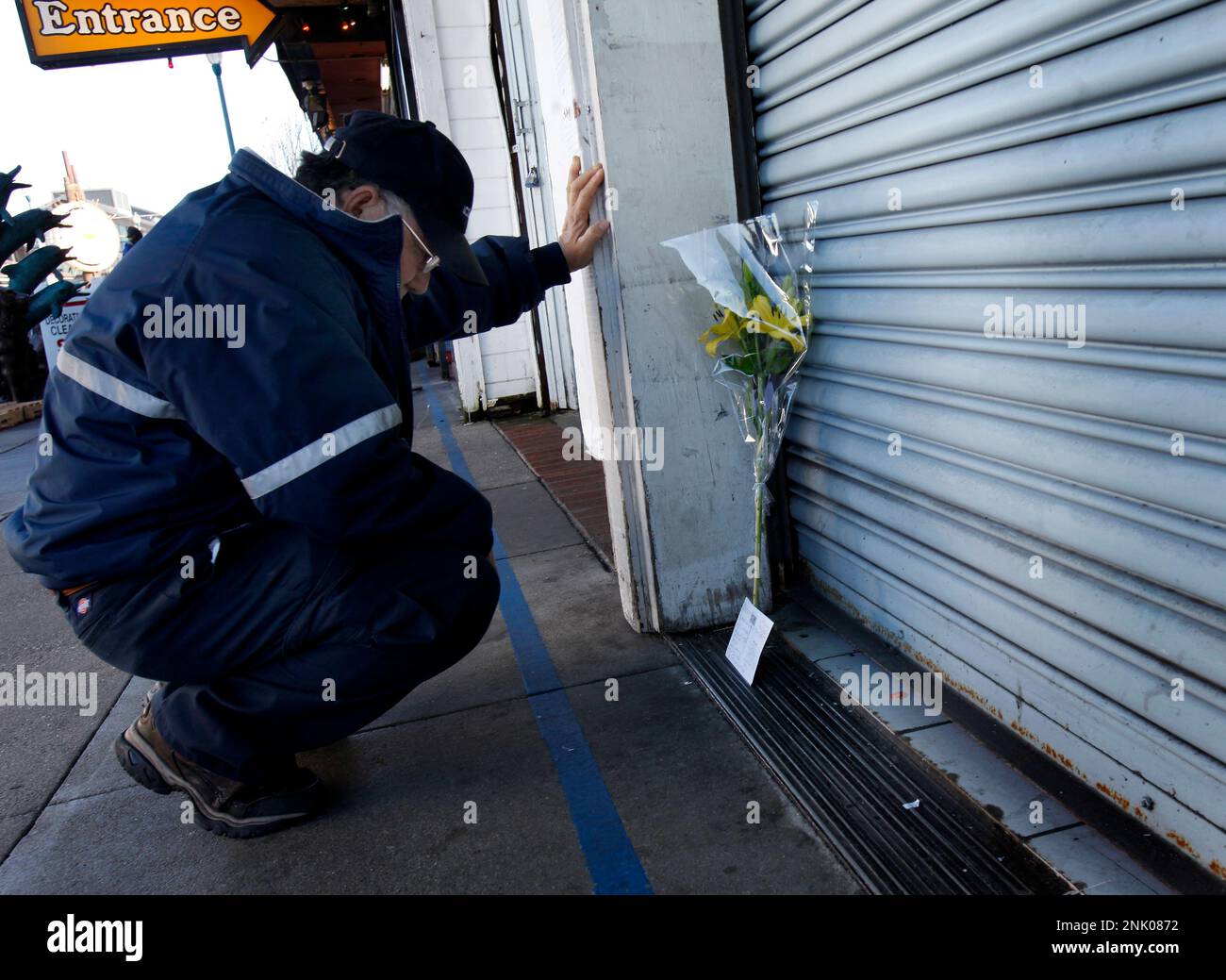 Mih Rasavong, who knew the victims, kneels and prays at the site of ...