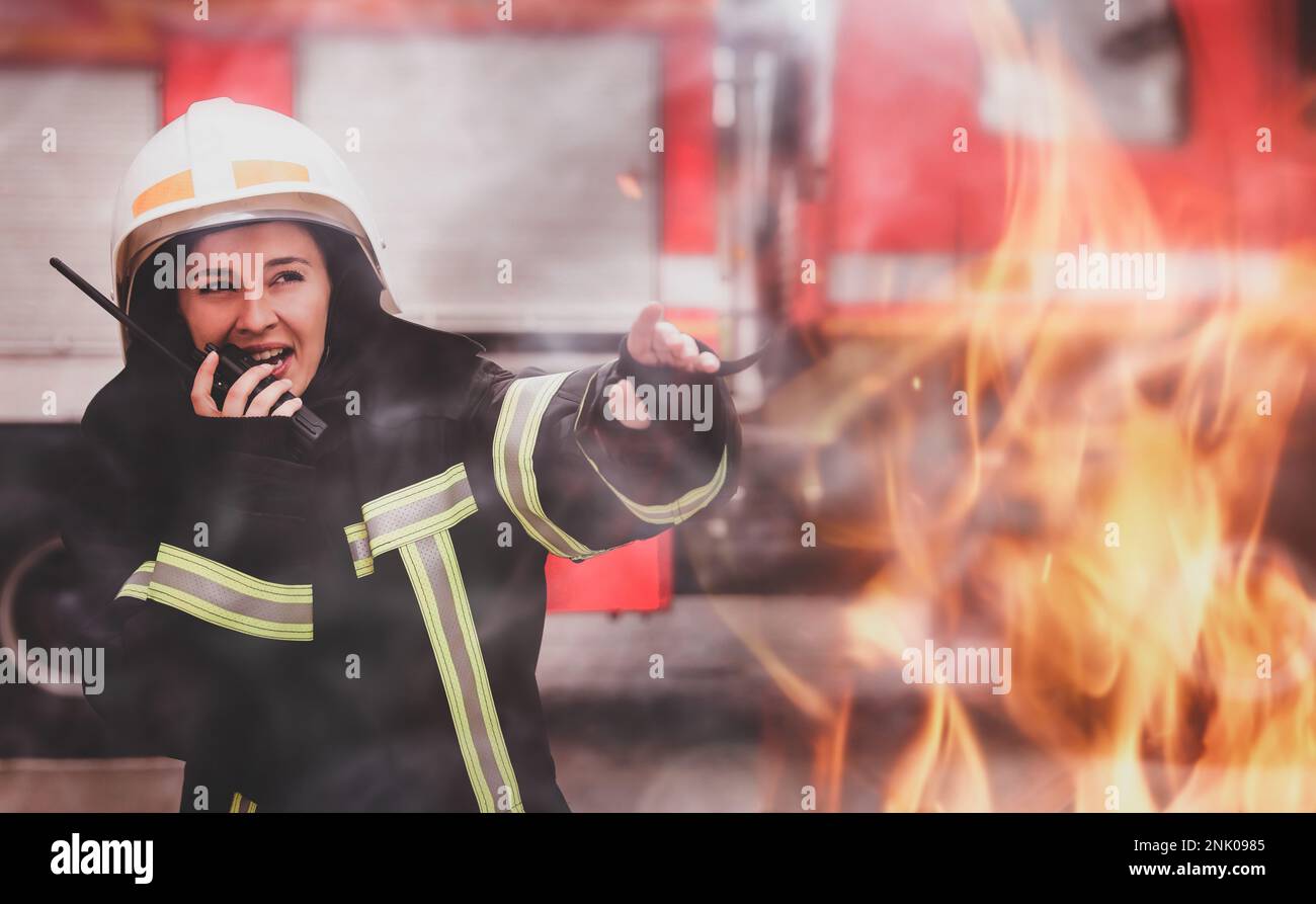 Firefighter in uniform using portable radio set near fire truck ...