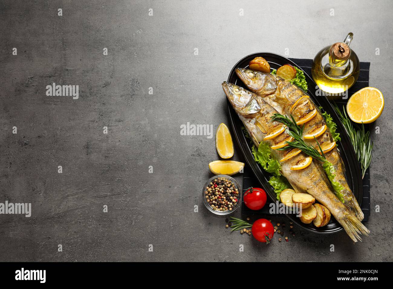 Tasty homemade roasted pike perches served on grey table, flat lay and ...