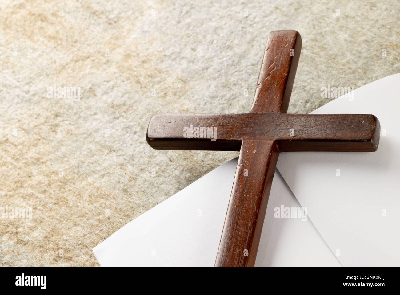 Image of close up of cross with notebook and copy space on stone ...