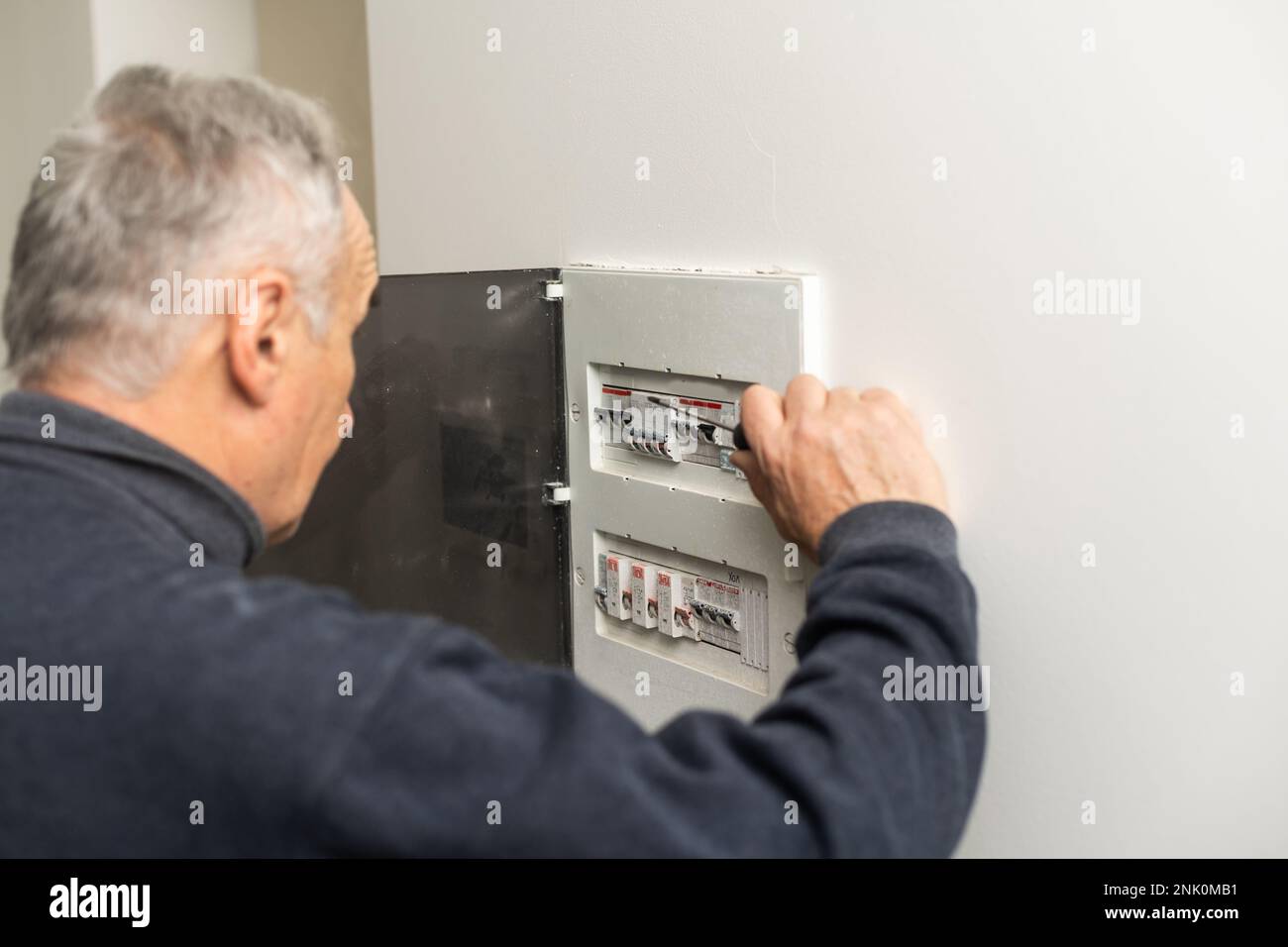Elder man fixing an electric meter Stock Photo - Alamy