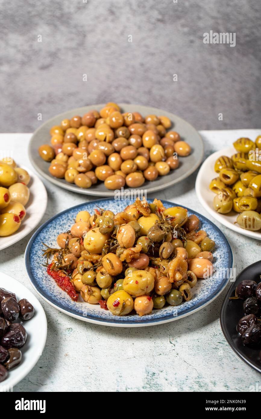 Olive varieties. Assortment of black and green olives on plate on gray ...