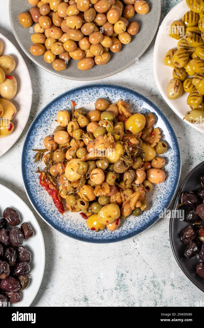 Olive varieties. Assortment of black and green olives on plate on gray ...
