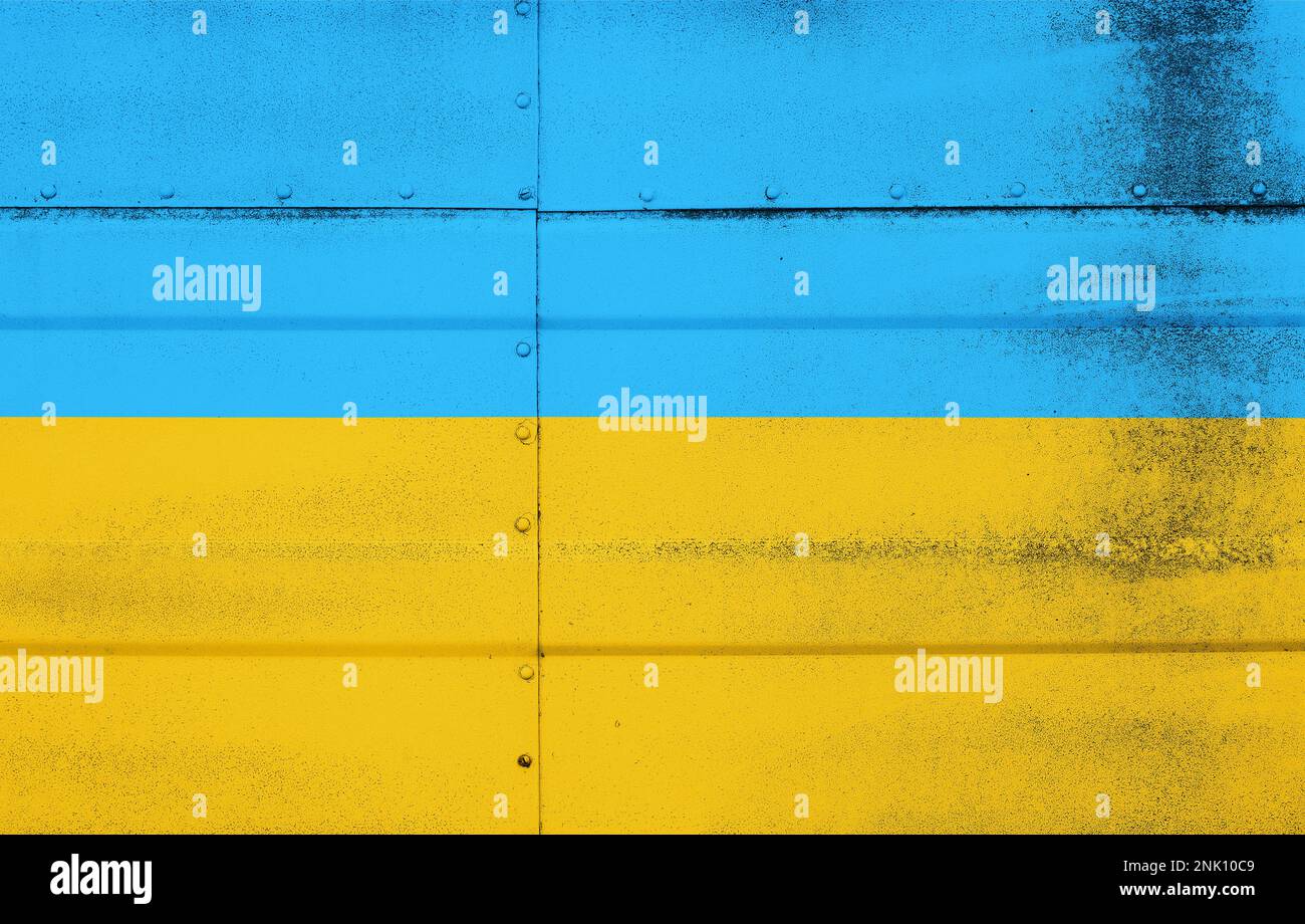 Grunge weathered national flag of Ukraine over studded steel armor ...