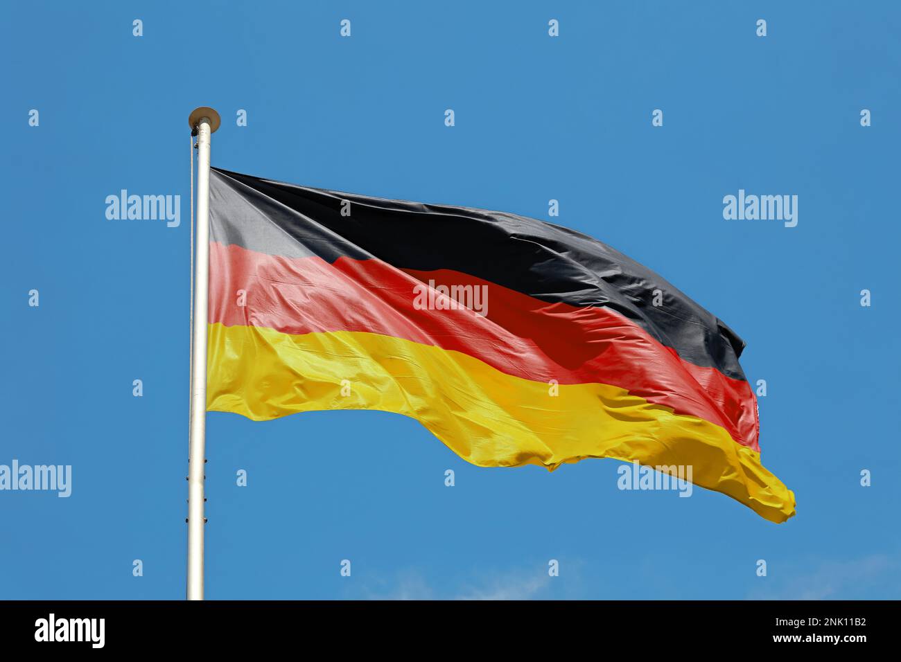 National flag of Germany flying and waving in the wind on flagstaff ...