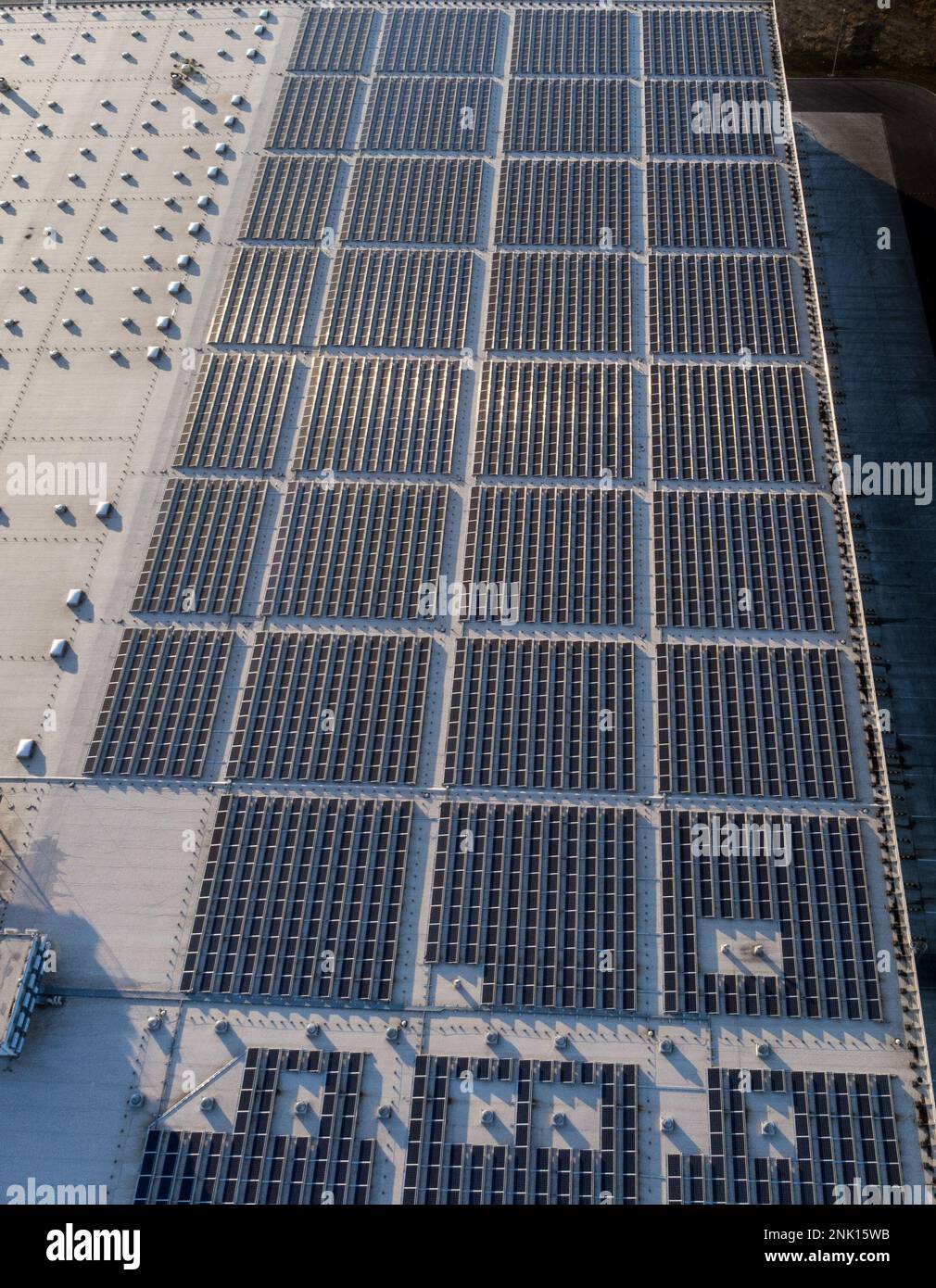 Large solar panel farm array on a commercial warehouse building, shot ...
