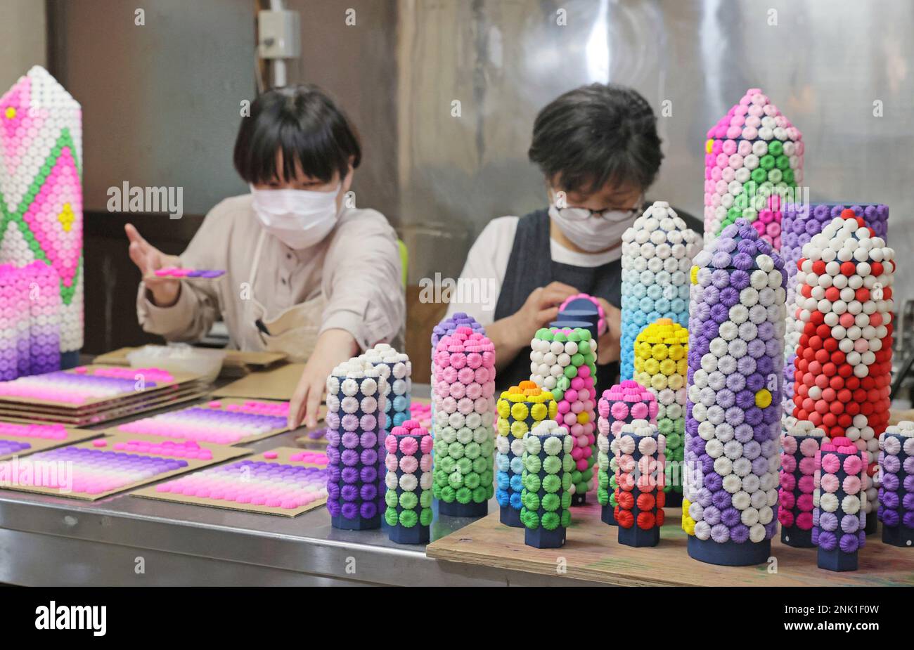 Workers assort and pack rakugan, dry confection of starch and sugar in ...